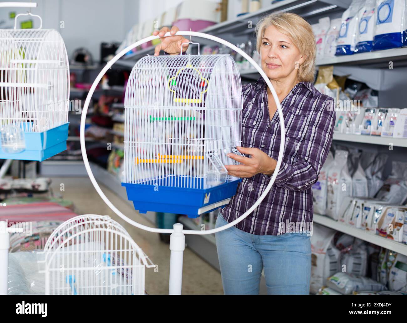 Lemale choose rainforest cage in store Stock Photo - Alamy