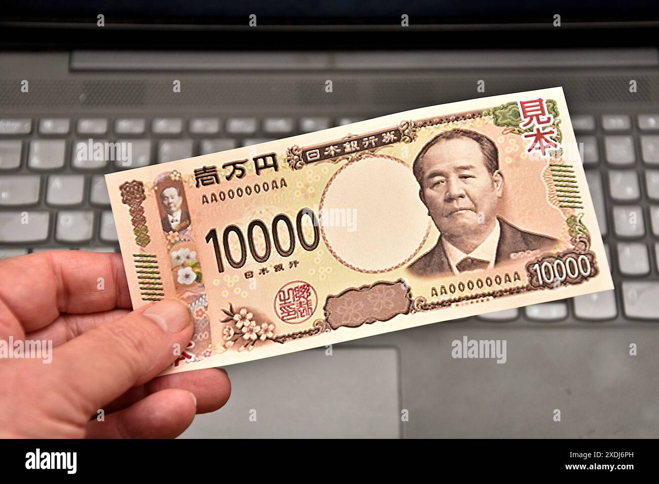 In this photo illustration, a man holds a sample of a Japanese 10,000 ...