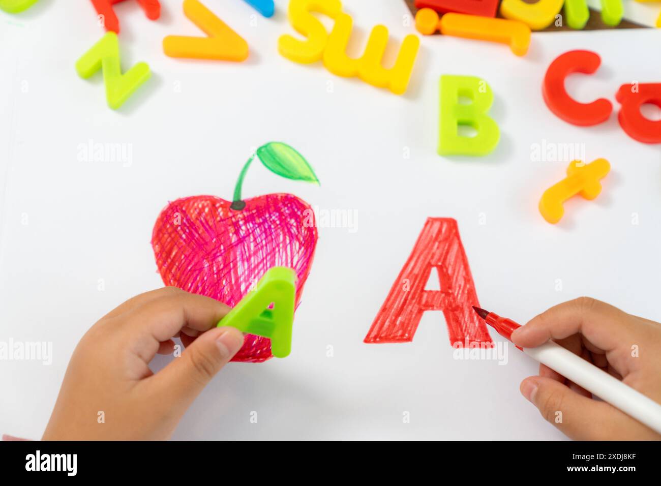 A little girl happily practicing writing the letters A, B, C Stock ...