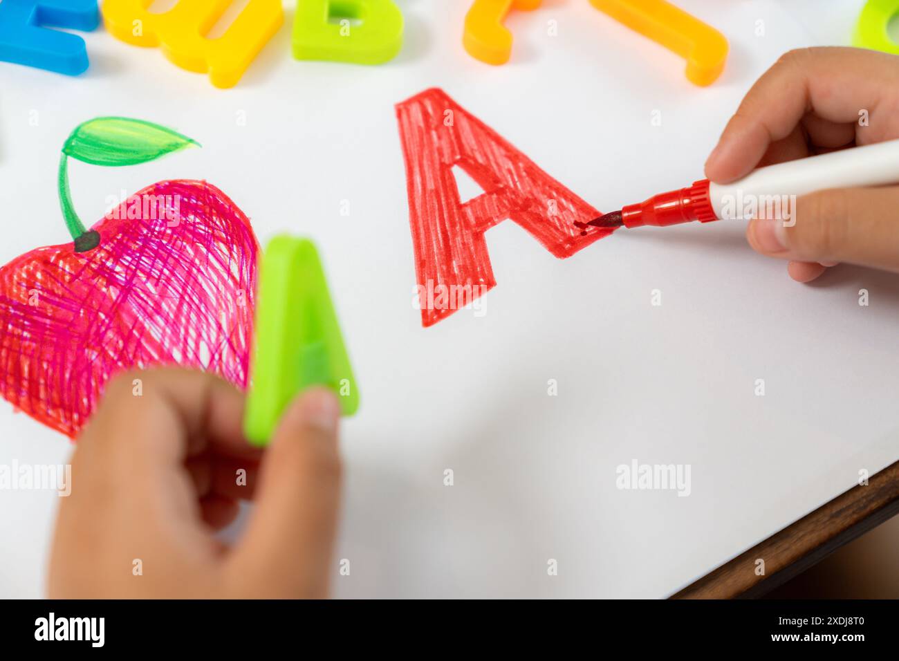 A little girl happily practicing writing the letters A, B, C Stock ...