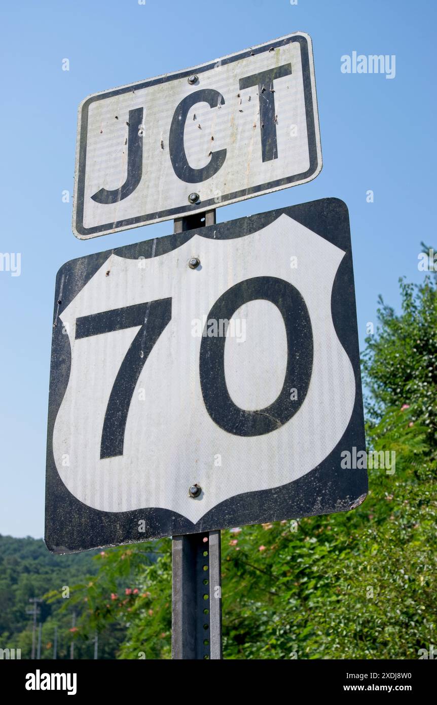 Road sign for the junction of Highway 70. The sign is worn and dirty ...