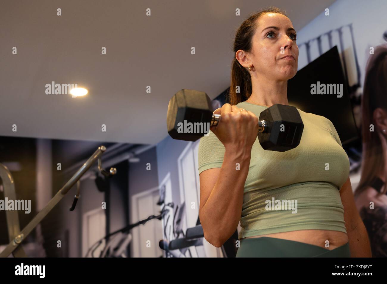 girl doing biceps with dumbbells in the gym with a lifted weight Stock ...