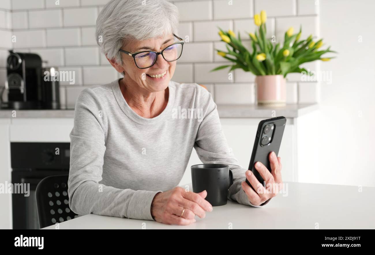 Cheerful Elderly Lady Video Calls Using A Messaging App Stock Photo - Alamy