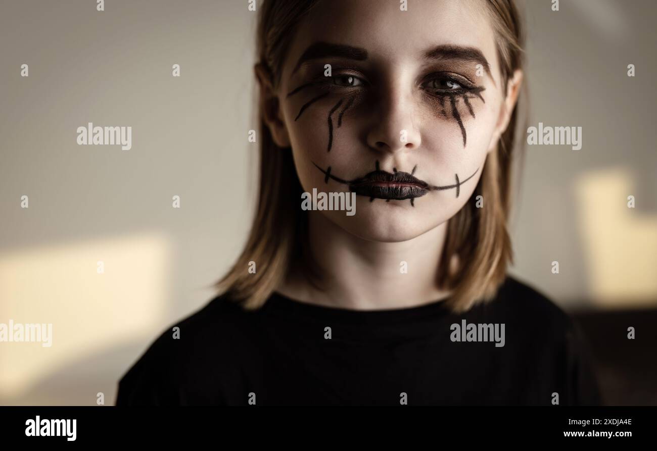 Little girl with spooky Halloween makeup brushed eyes looking at camera ...