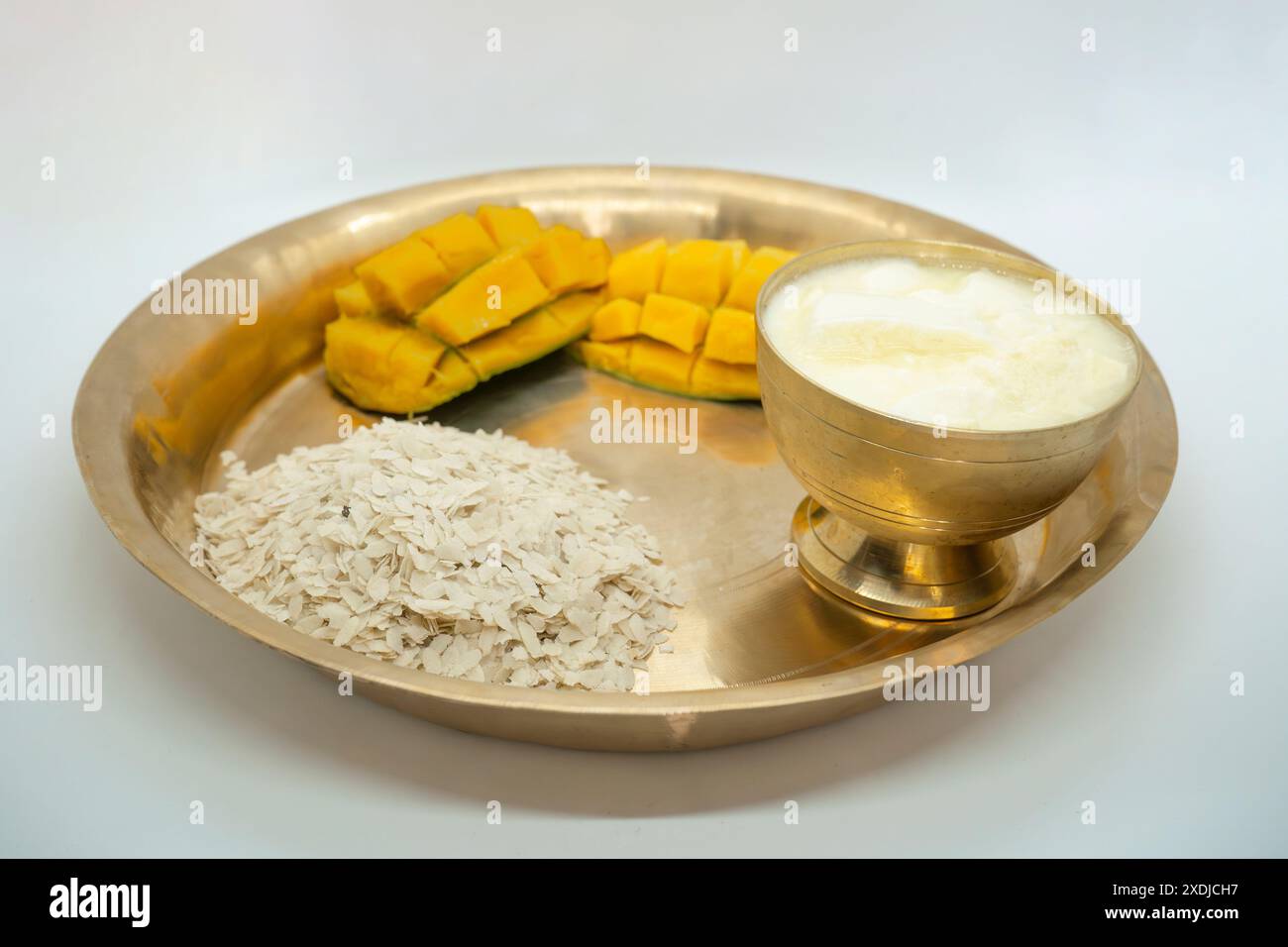 A copper plate and bowl of Dahi Chiura aka Yoghurt and Rice Flakes for ...
