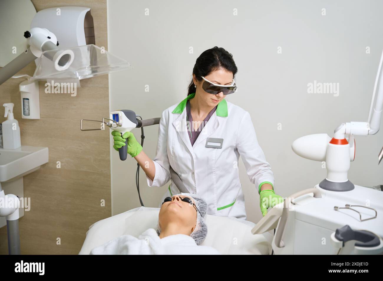 Specialist dermatologist sets up a modern laser device for operation ...