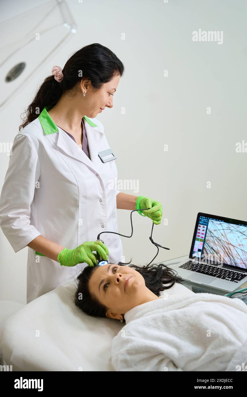 Trichologist performs a diagnostic procedure using a trichoscope Stock ...