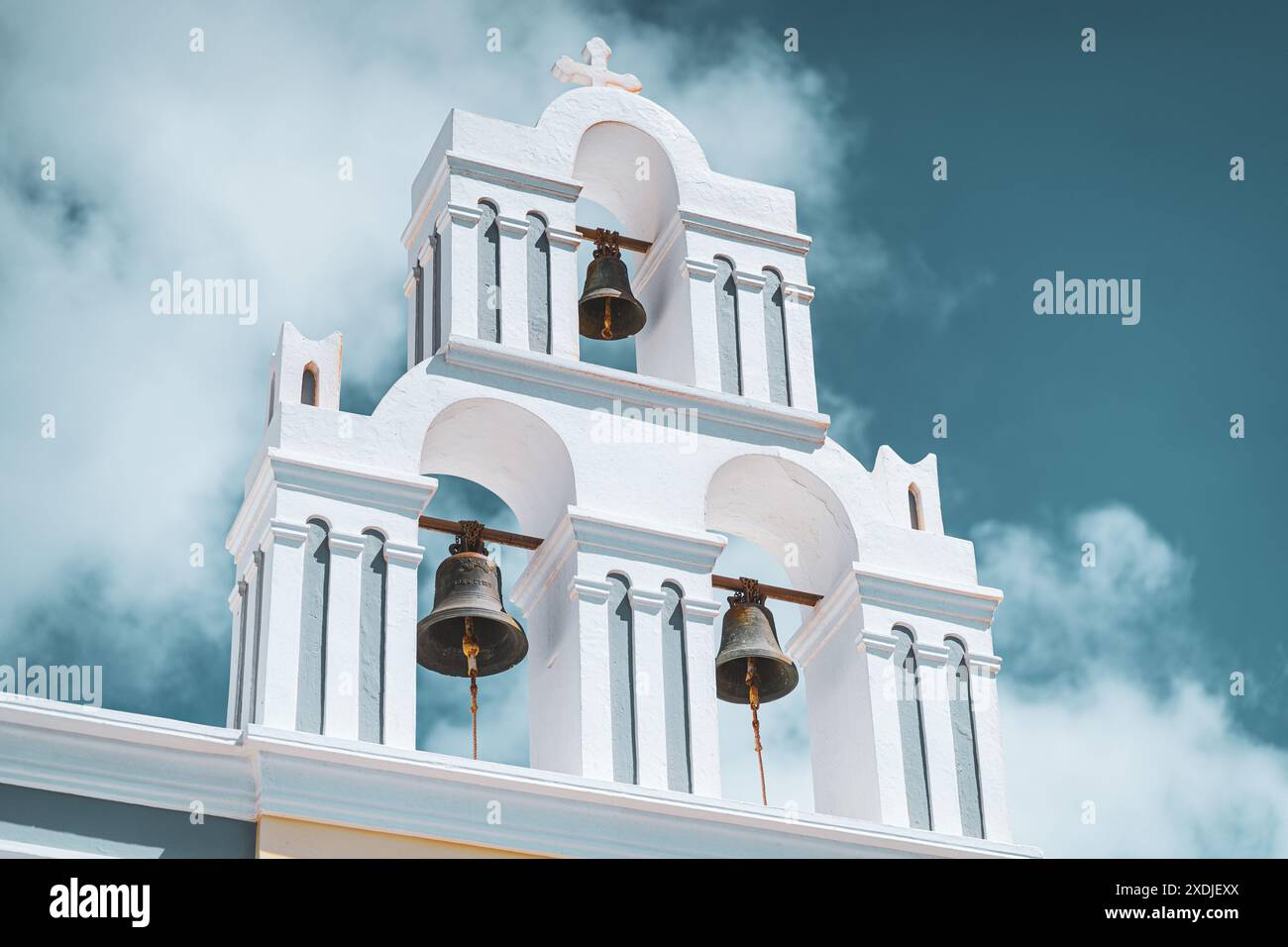 Traditional white bell tower with three bronze bells in Santorini ...