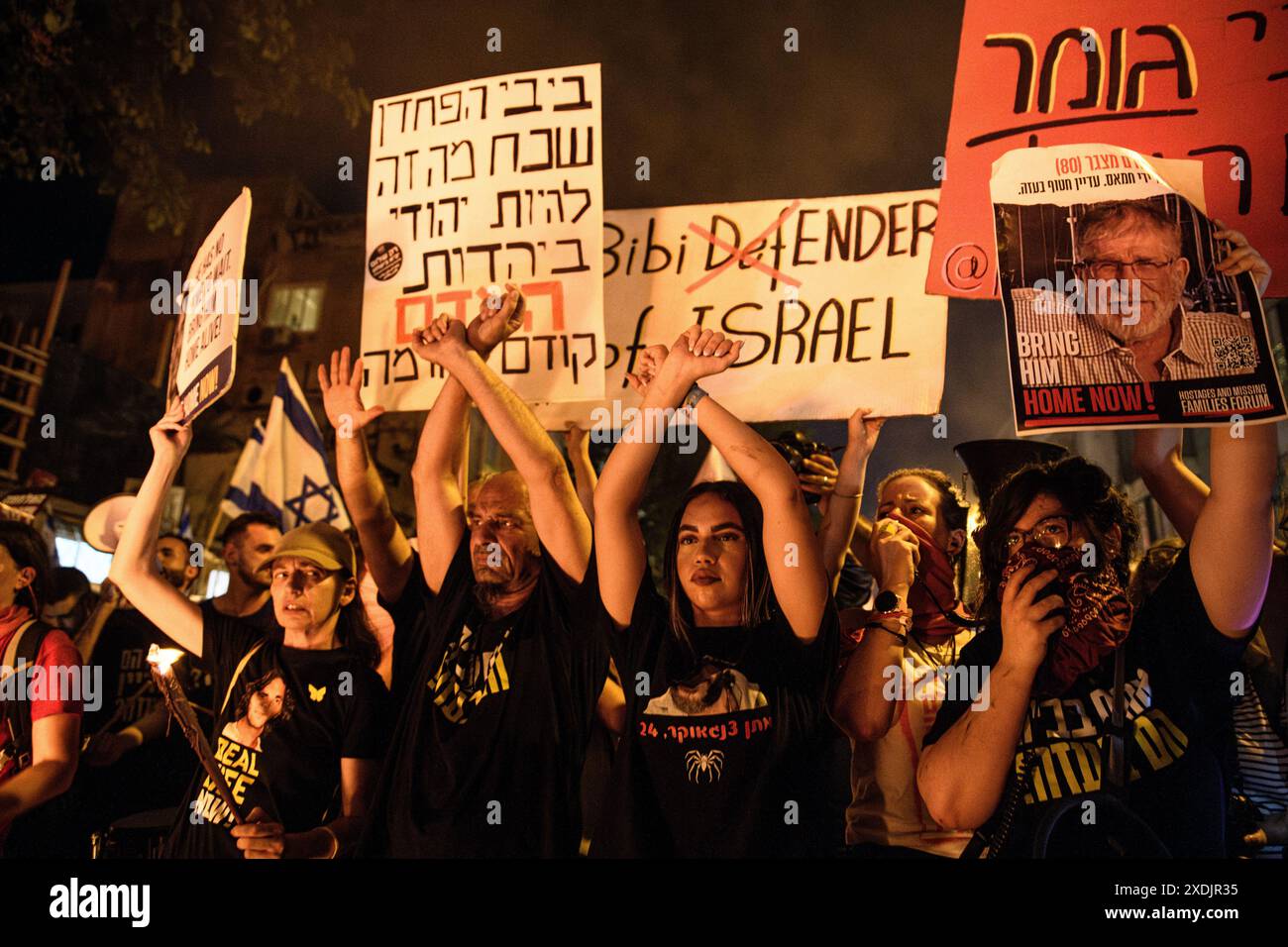 Israeli hostage’s family members cross their hands up next of a bonfire ...