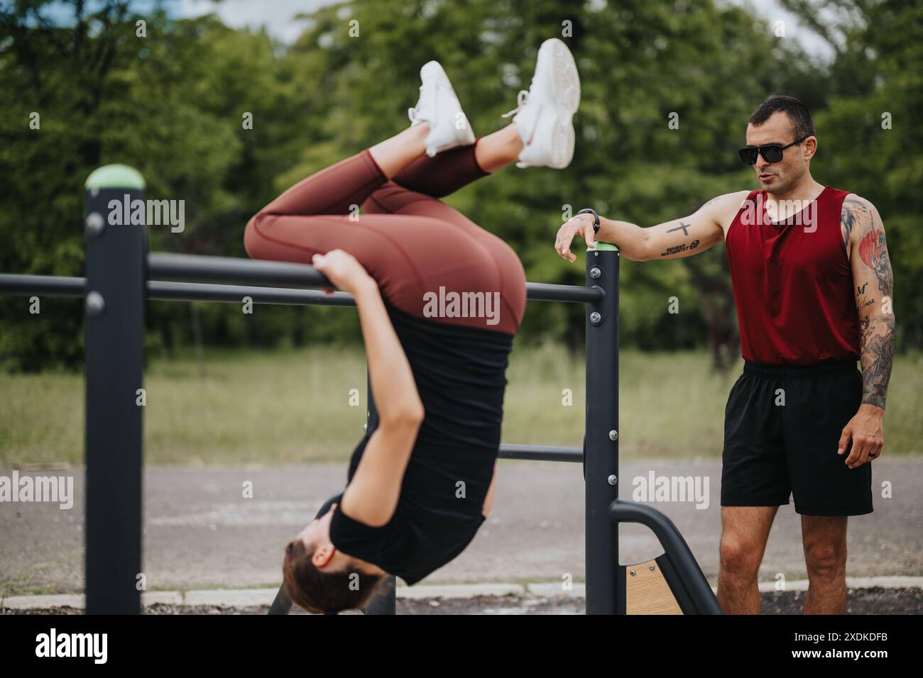 Female athlete performing an upside-down exercise watched by a male ...