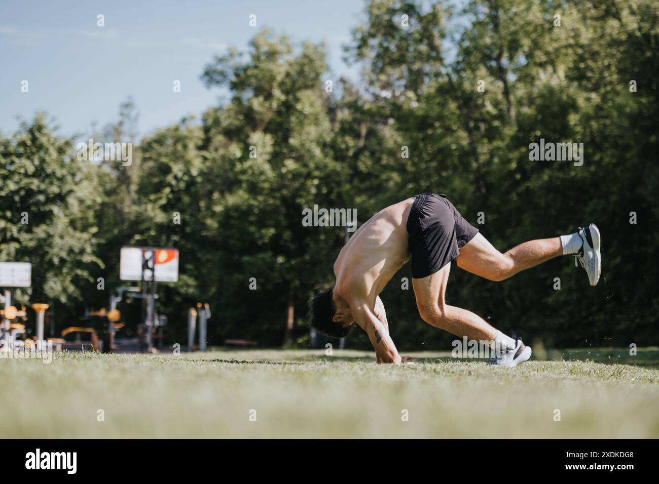 Athletic man practicing outdoor gymnastics in sunny park setting Stock ...