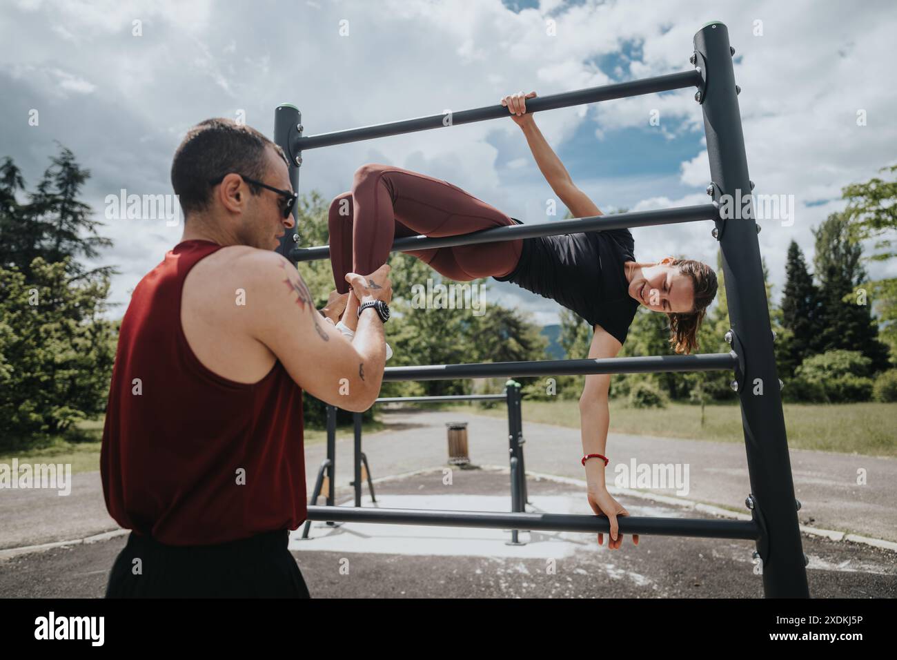 Fit couple practicing calisthenics at an outdoor park gym during summer ...
