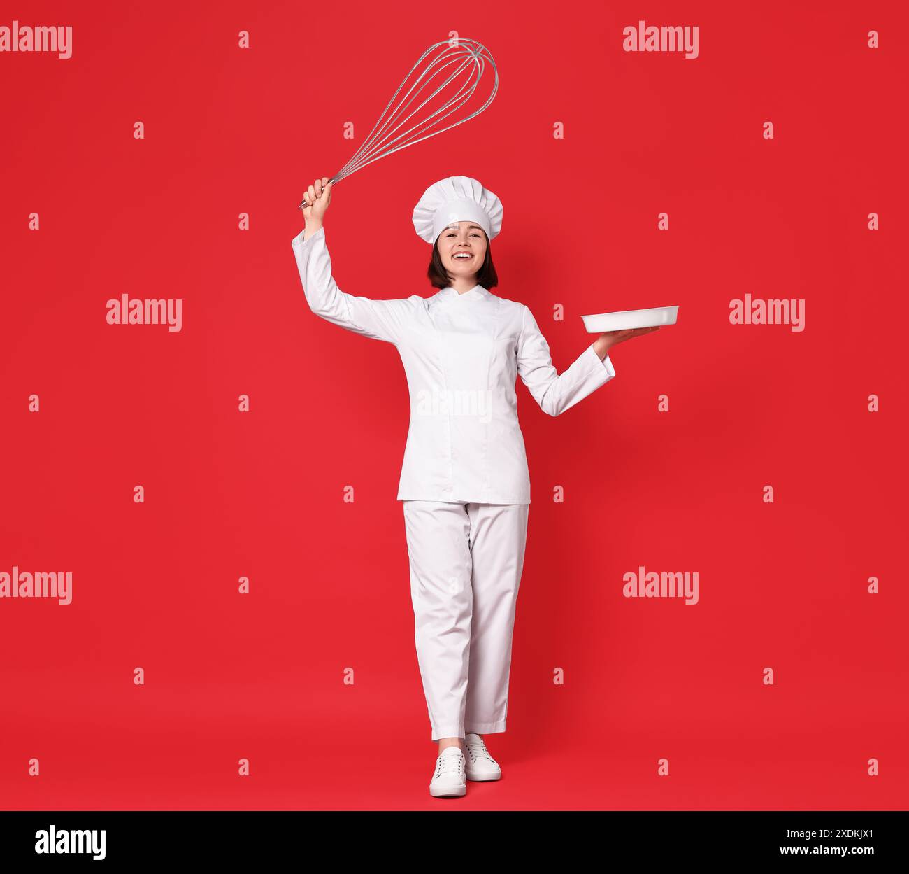 Happy pastry chef with big whisk and dishware on red background Stock ...