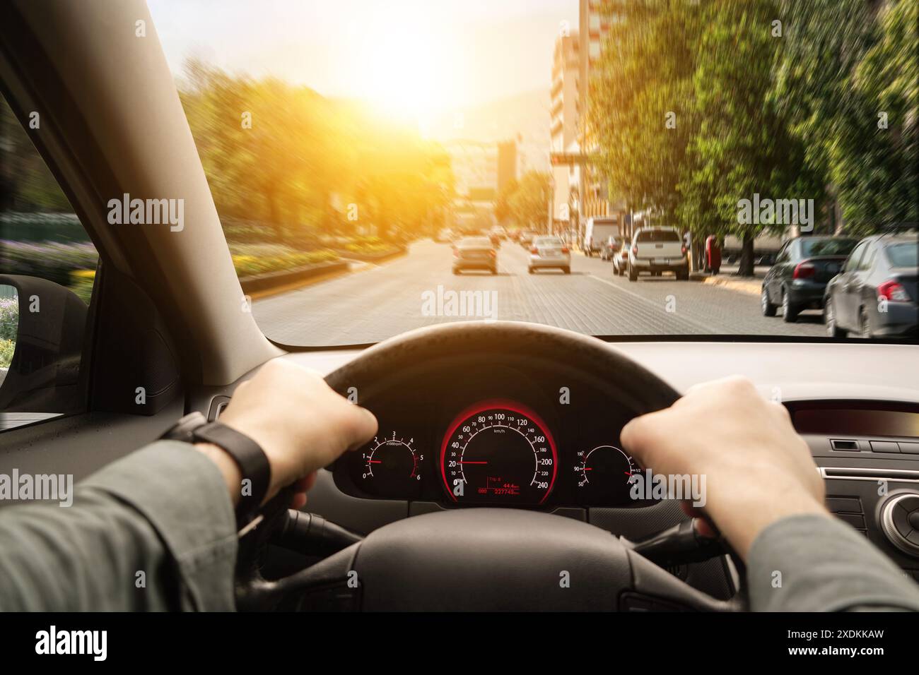 Driving car, view from driver's seat. Man holding hands on steering ...