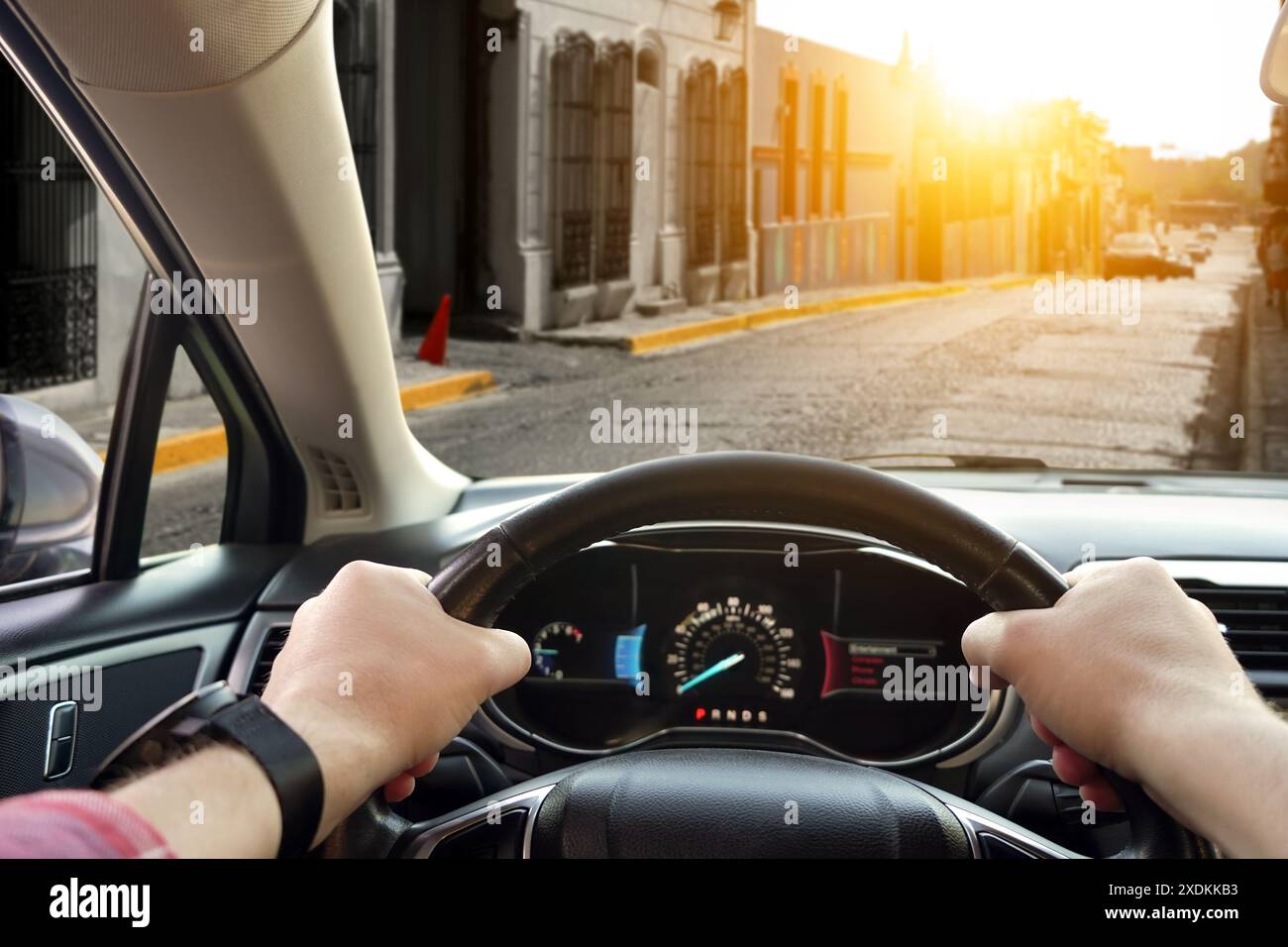 Driving car, view from driver's seat. Man holding hands on steering ...