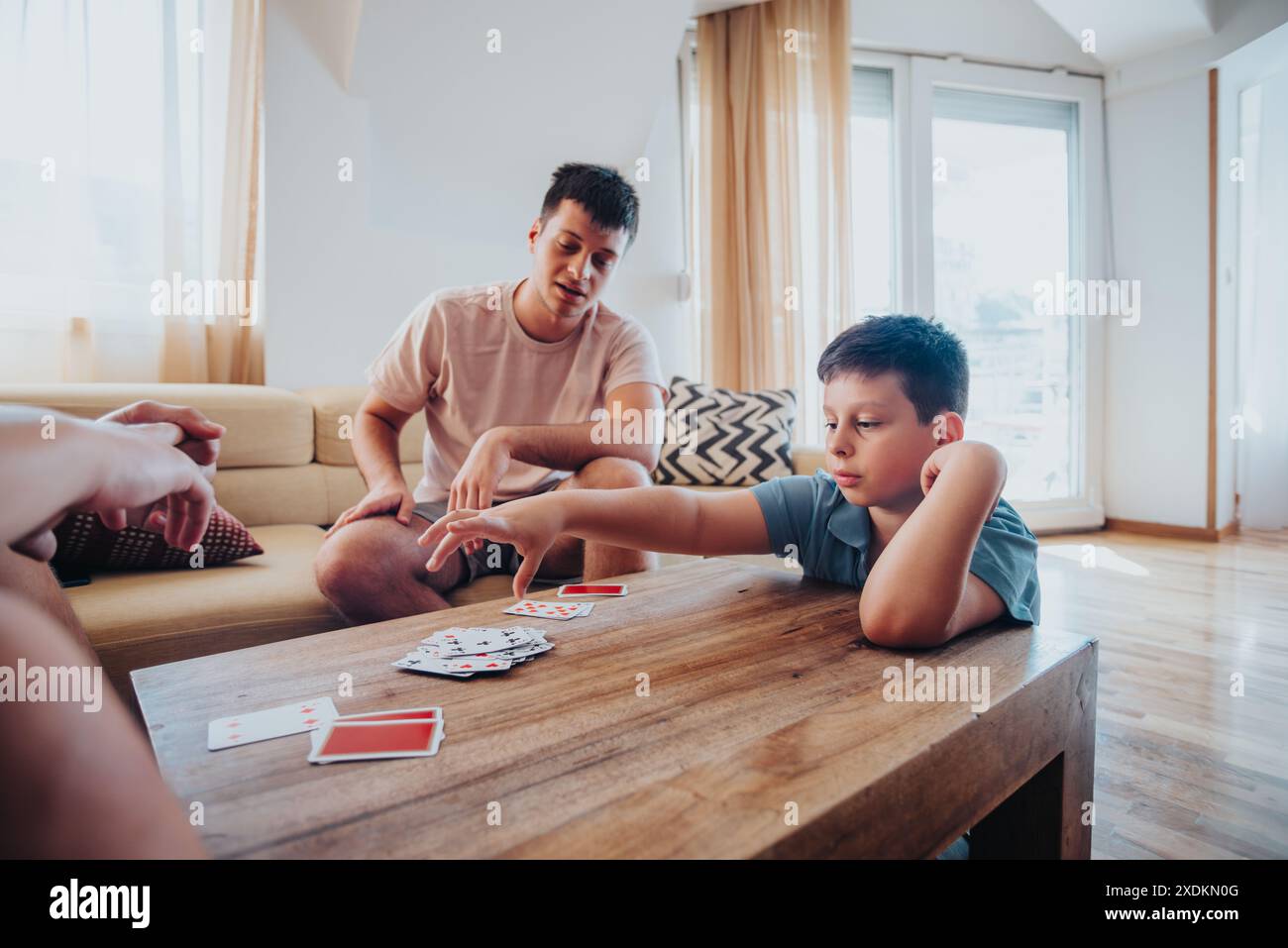 Family bonding activity playing card games in a cozy living room Stock ...
