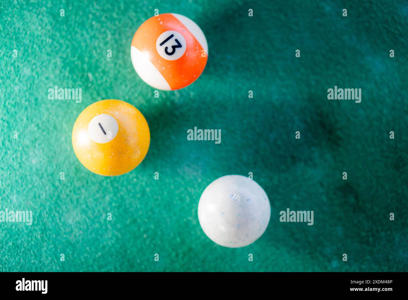 Three billiard balls on a green pool table. The balls are numbered 1 ...
