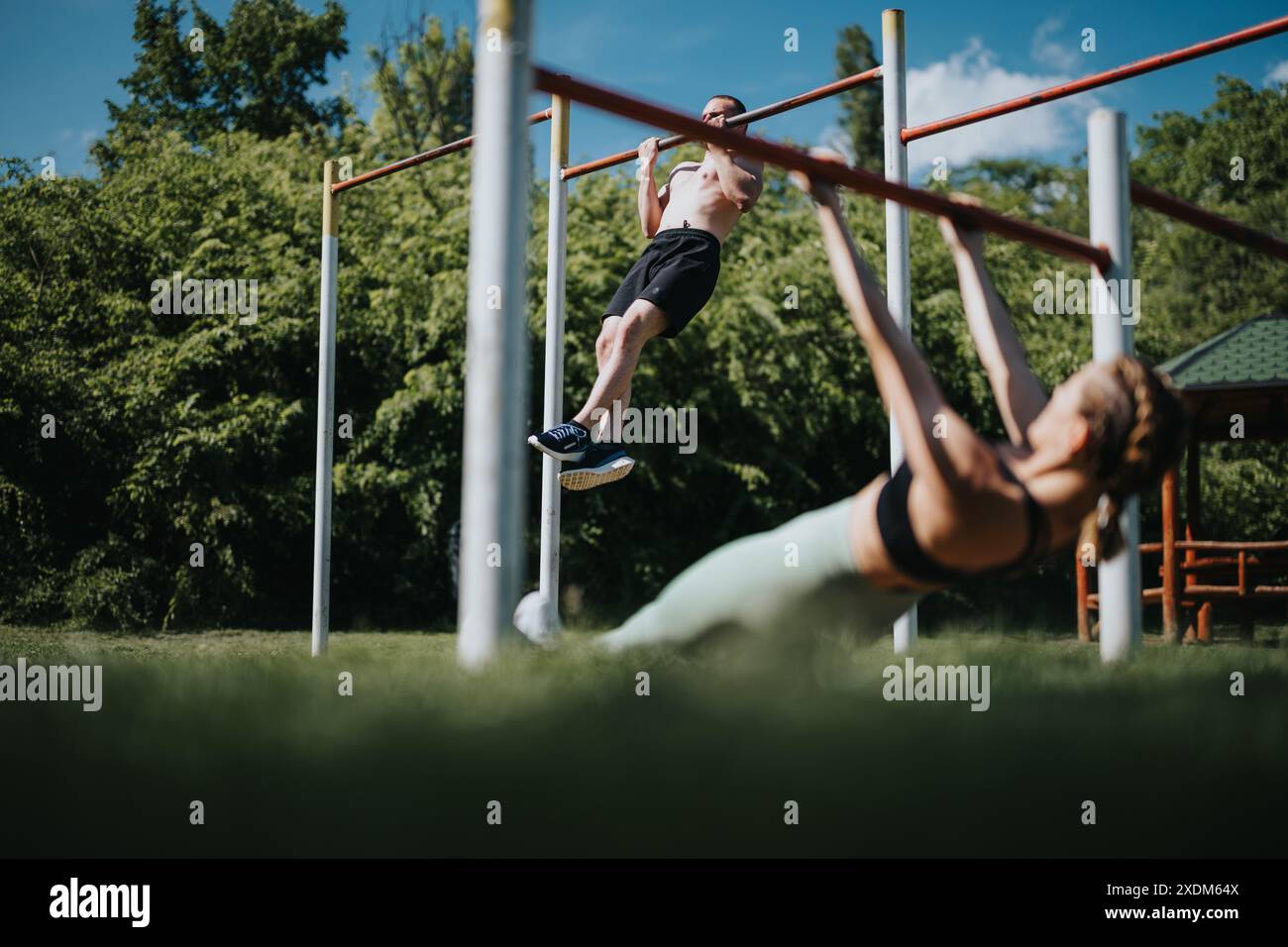 Fitness enthusiasts performing calisthenics exercises on parallel bars ...