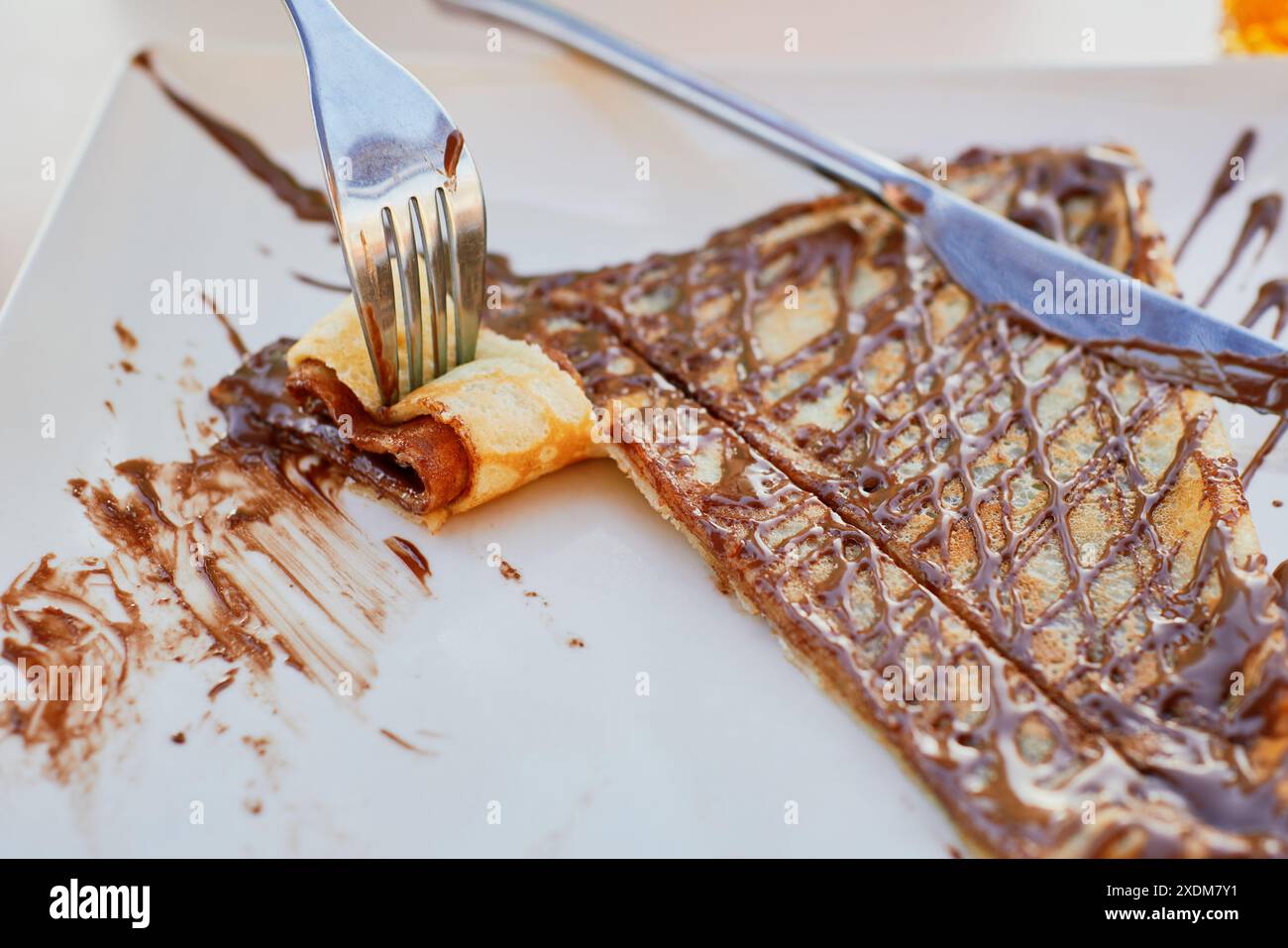 eating a piece of crepe on a plate Stock Photo - Alamy