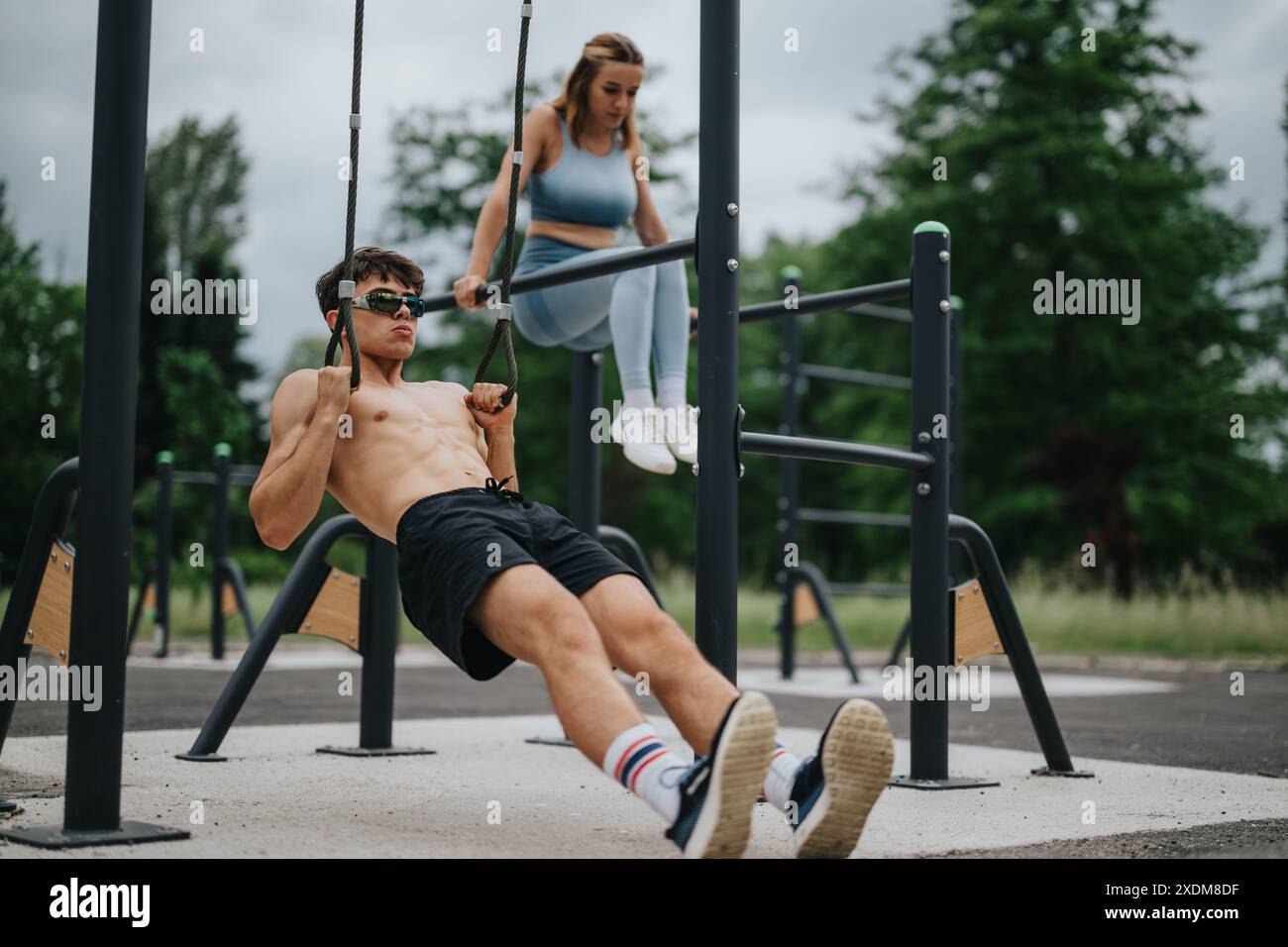 Young athletes performing an outdoor calisthenics workout in a park ...