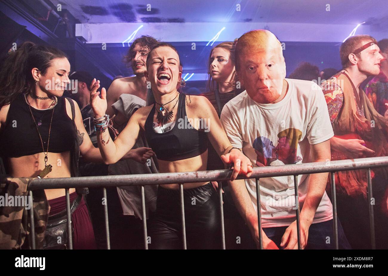 Young girls at nightclub dance and laugh whist DJ plays. One person ...