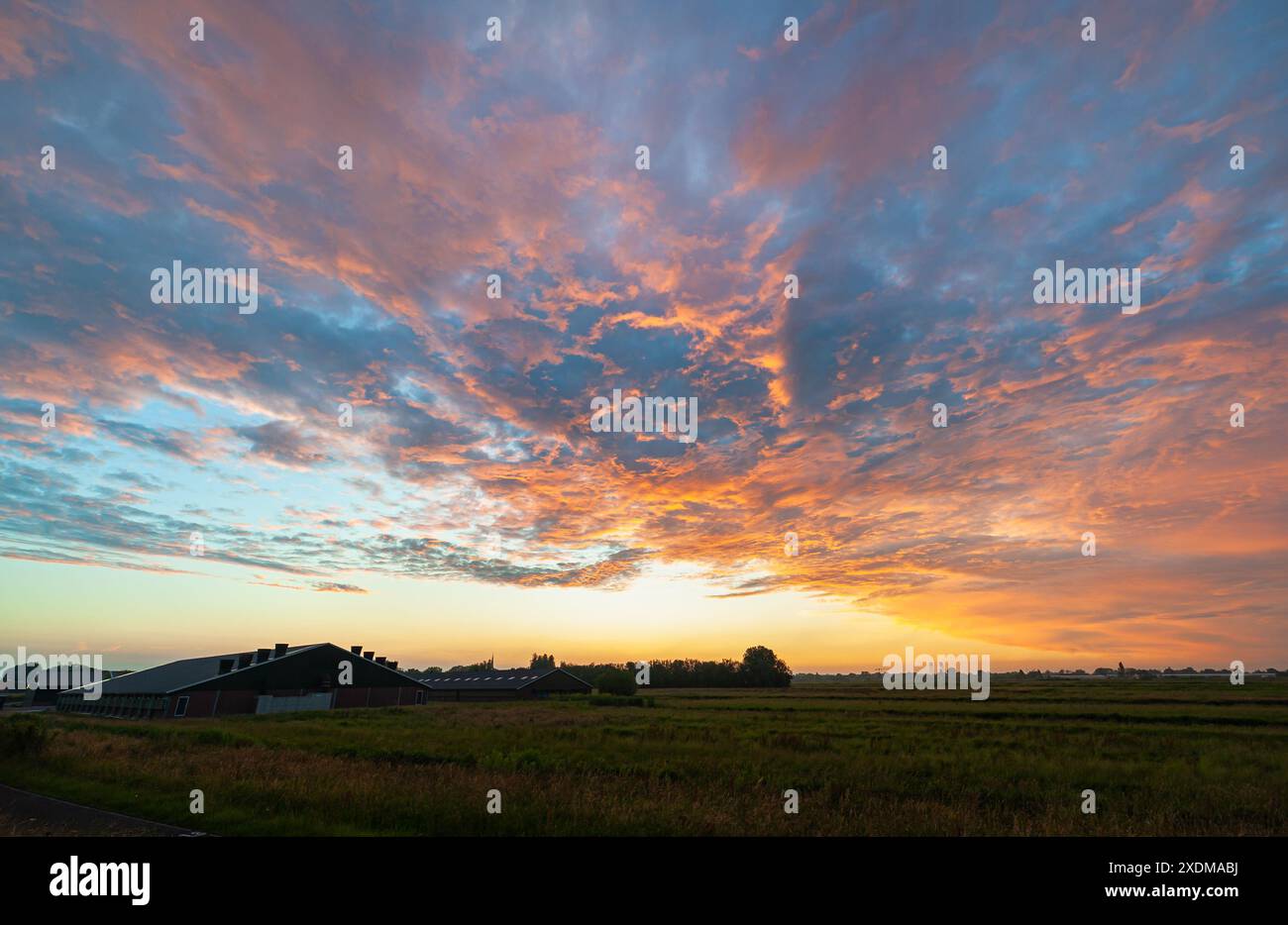 Beautiful colors in the clouds over a farm during sunset Stock Photo ...