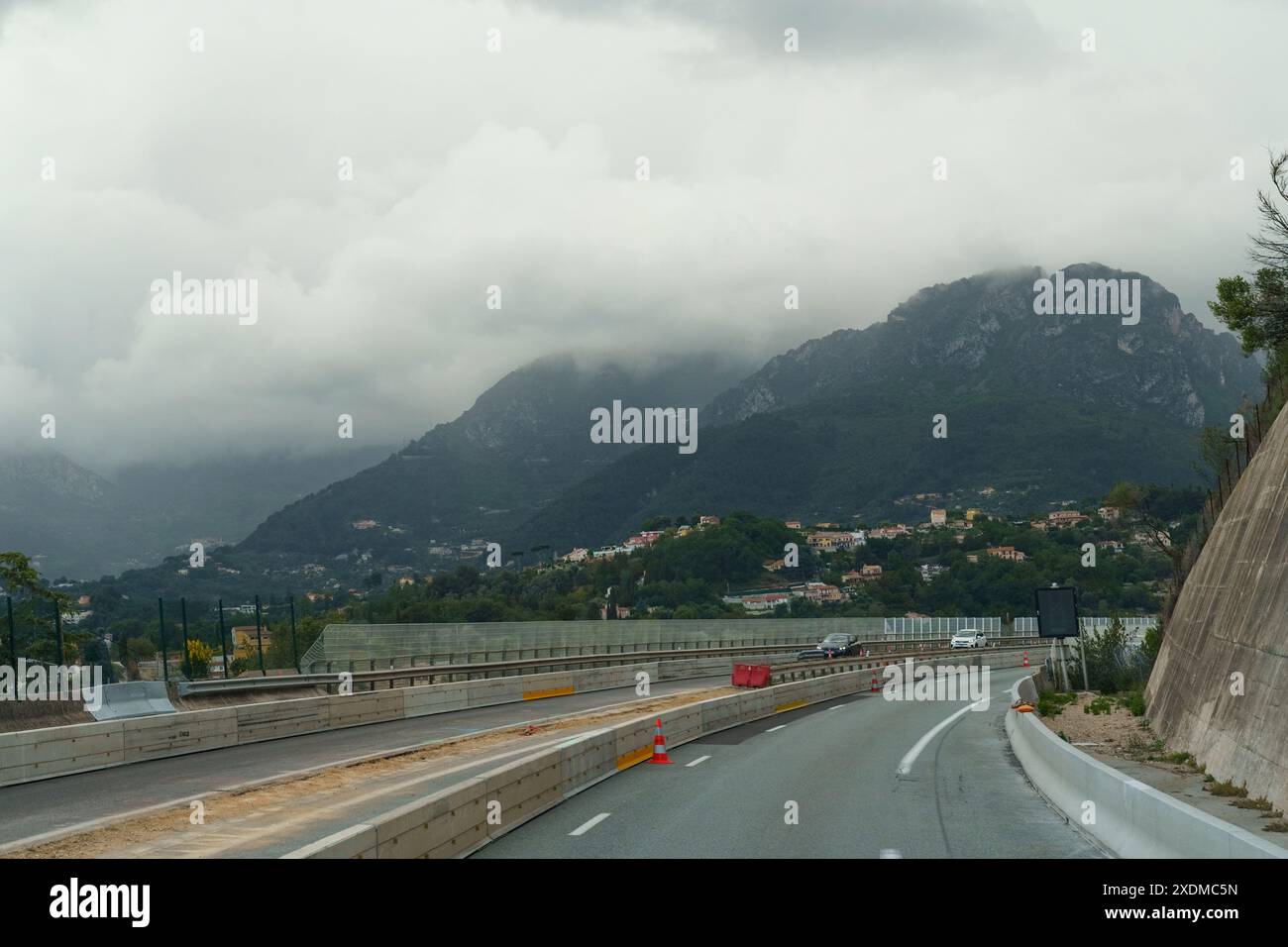 A view from a car driving along a road through the Italian Alps. The ...