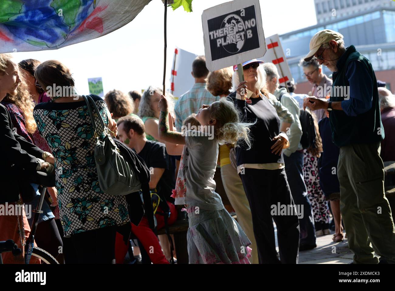 Families at climate change march and protest with signs and flags ...