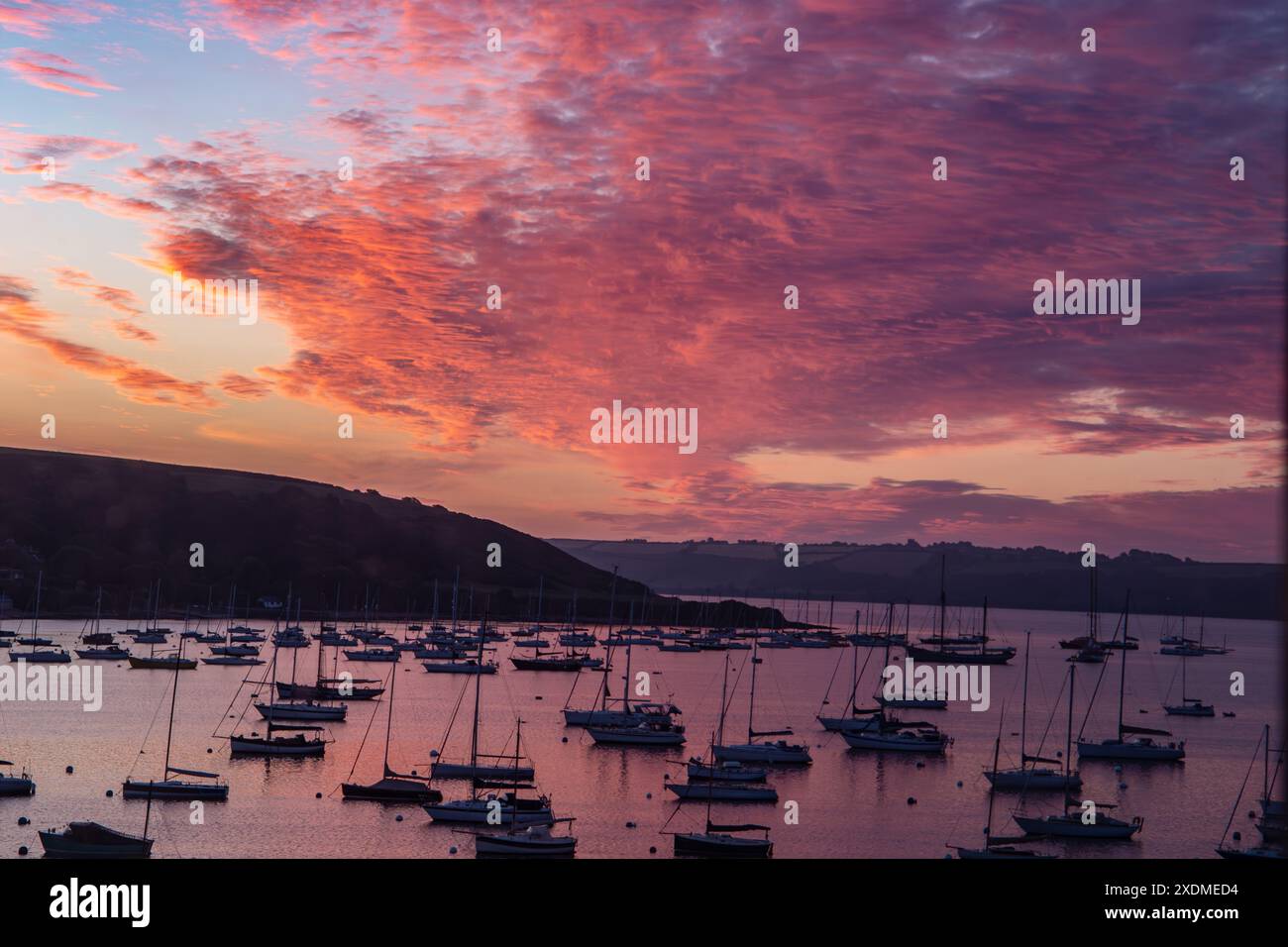Vibrant sunrise skies over the peaceful river Fal at Falmouth Cornwall ...