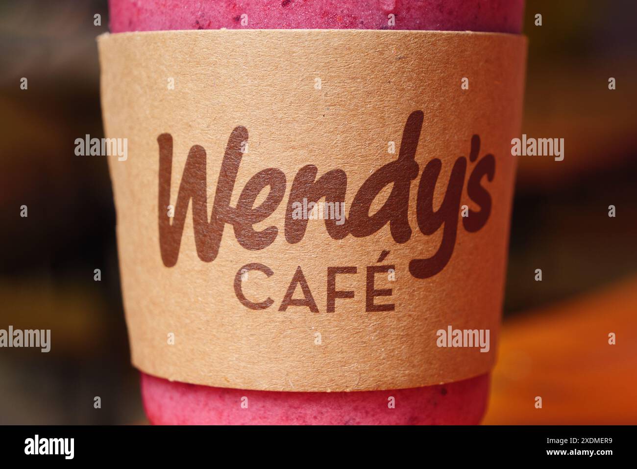 Wendys Cafe plastic cup filled with a berry smoothie, featuring a brown paper sleeve with the ...