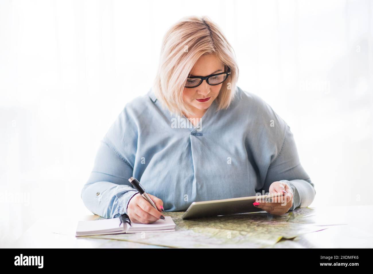 Overweight woman working from homeoffice, sitting at table, holding ...