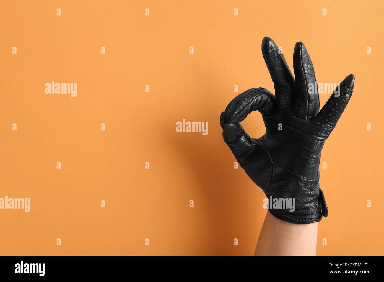 Female hand in black leather glove showing OK gesture on color ...