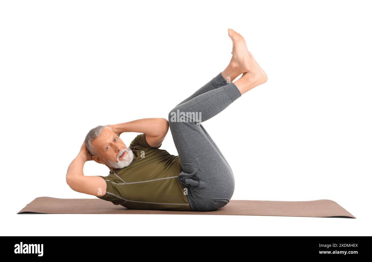 Sporty mature man training on mat against white background Stock Photo ...