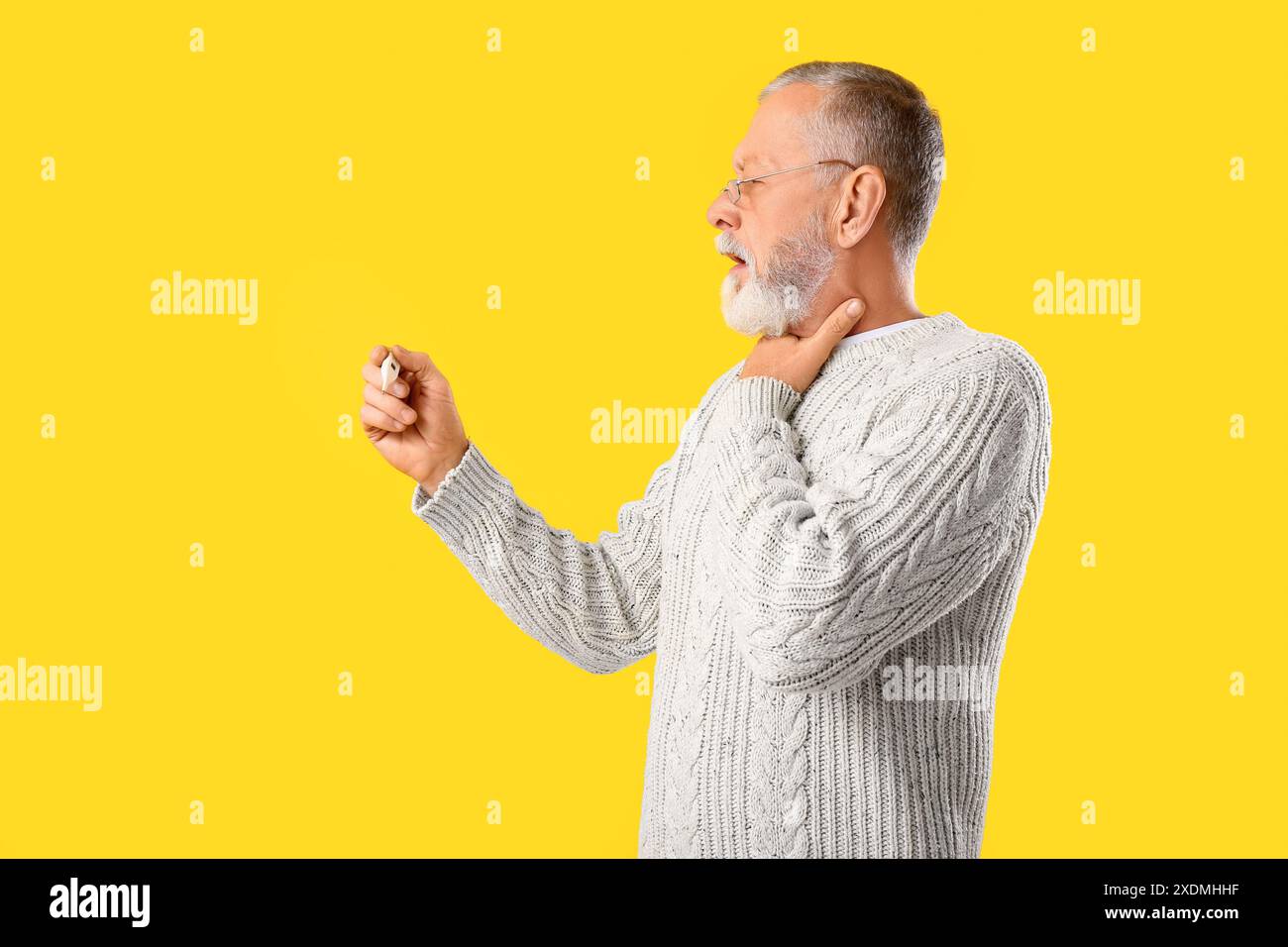 Old man with sore throat holding thermometer on yellow background Stock ...