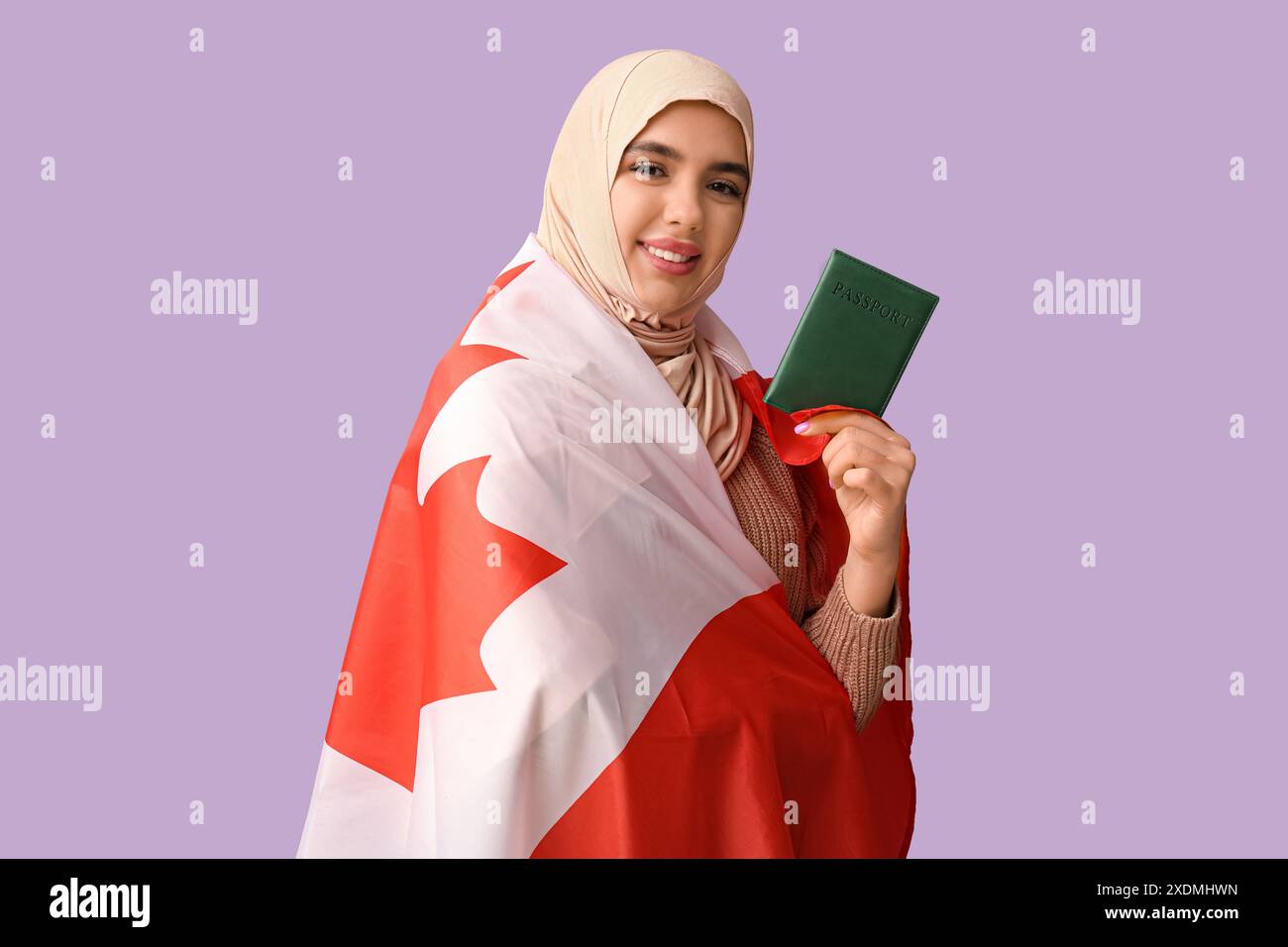 Beautiful young Muslim woman with Canadian flag and passport on purple ...