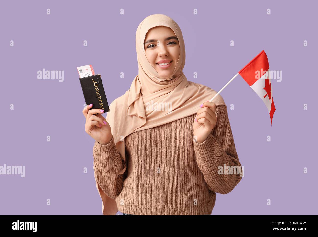 Beautiful young Muslim woman with Canadian flag, ticket and passport on ...