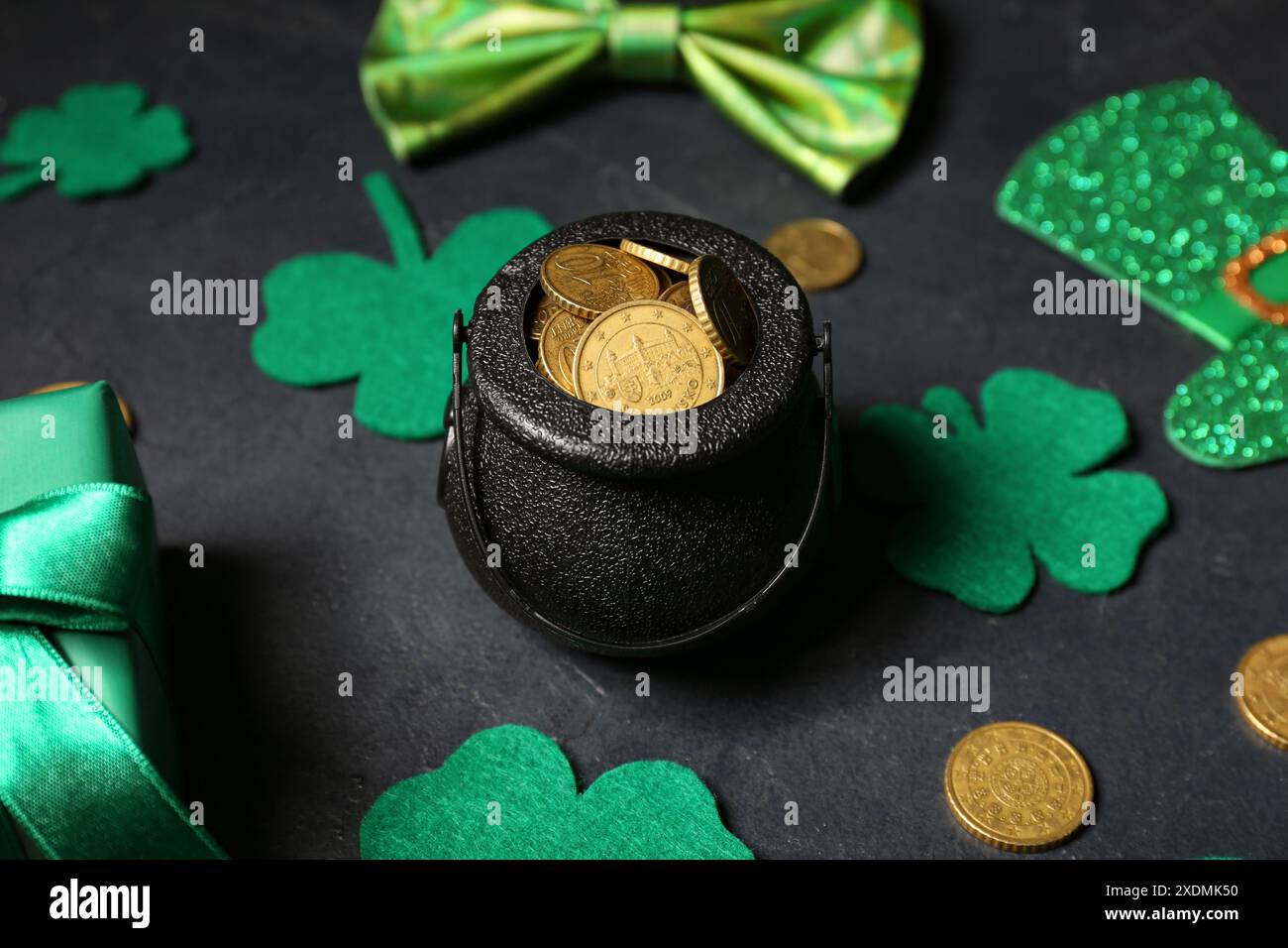 Leprechaun pot with golden coins and clover leaves on black background ...