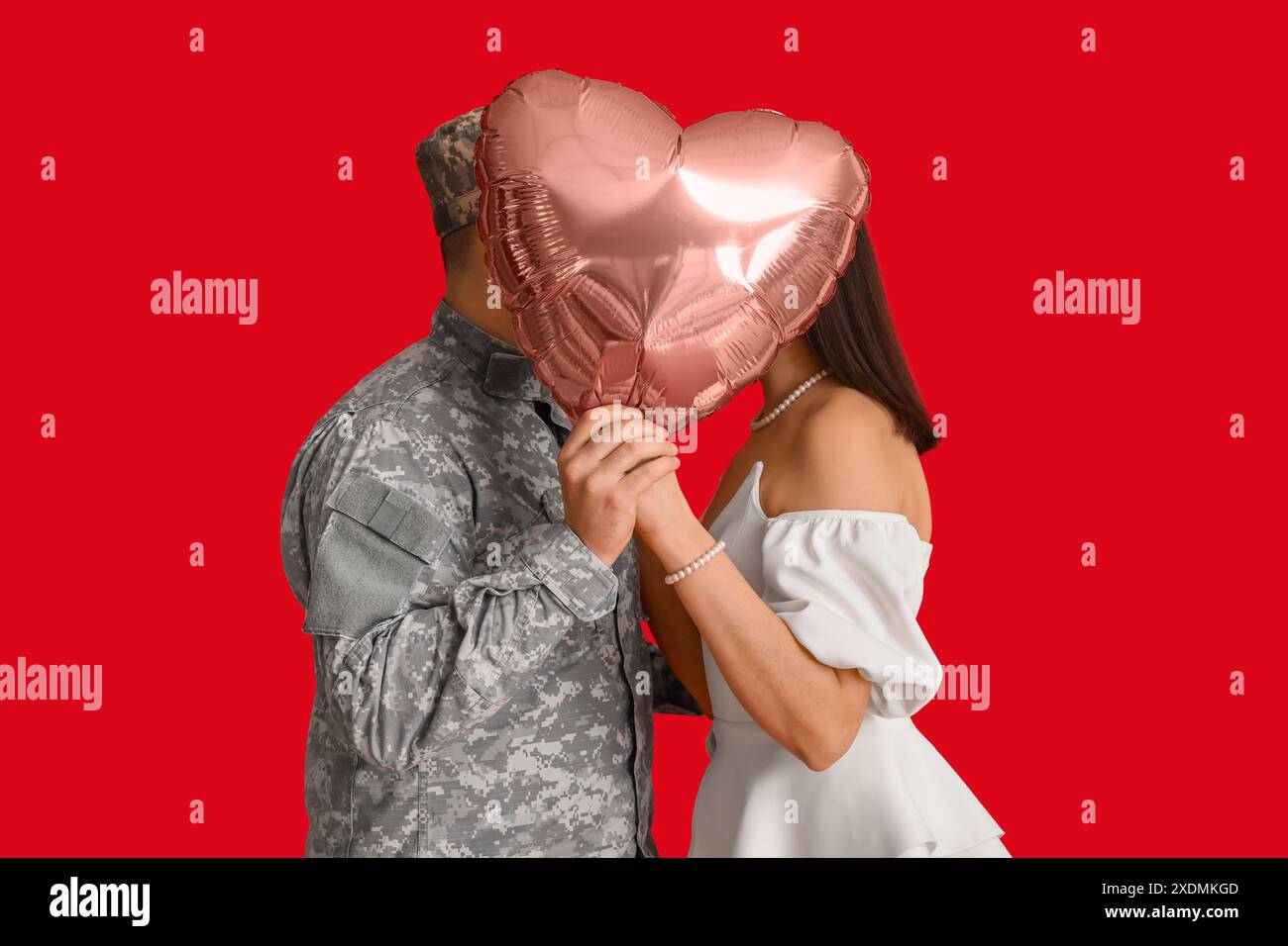 Man in military uniform and his wife kissing behind heart-shaped ...