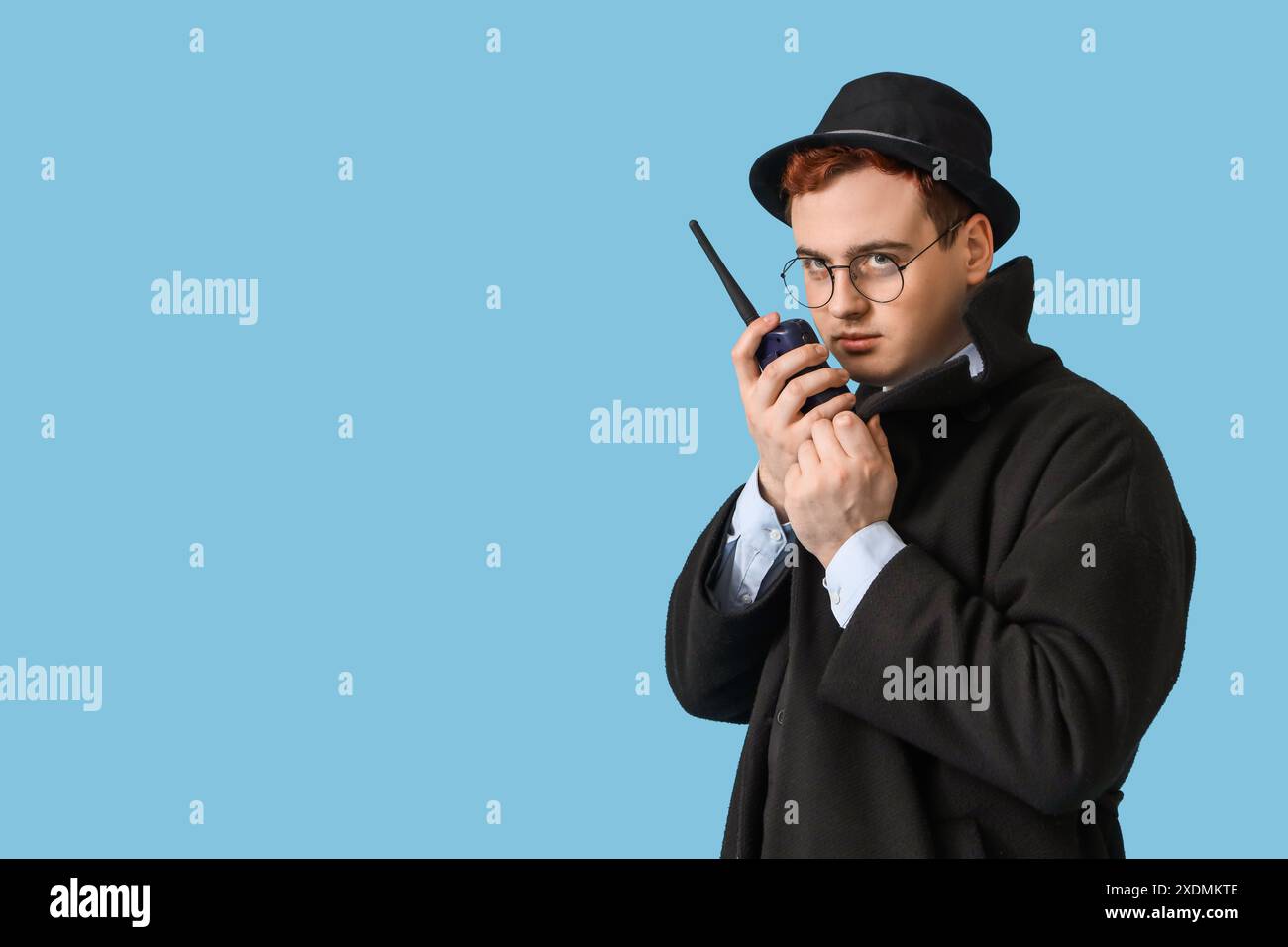 Male spy with two-way radio on blue background Stock Photo - Alamy