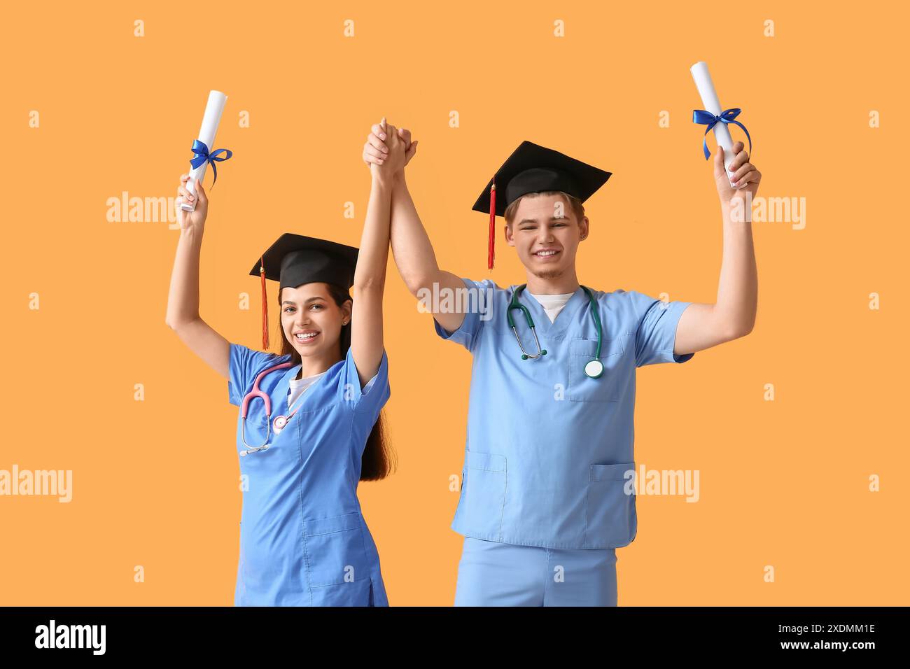 Happy medical graduate couple with diplomas on yellow background Stock ...