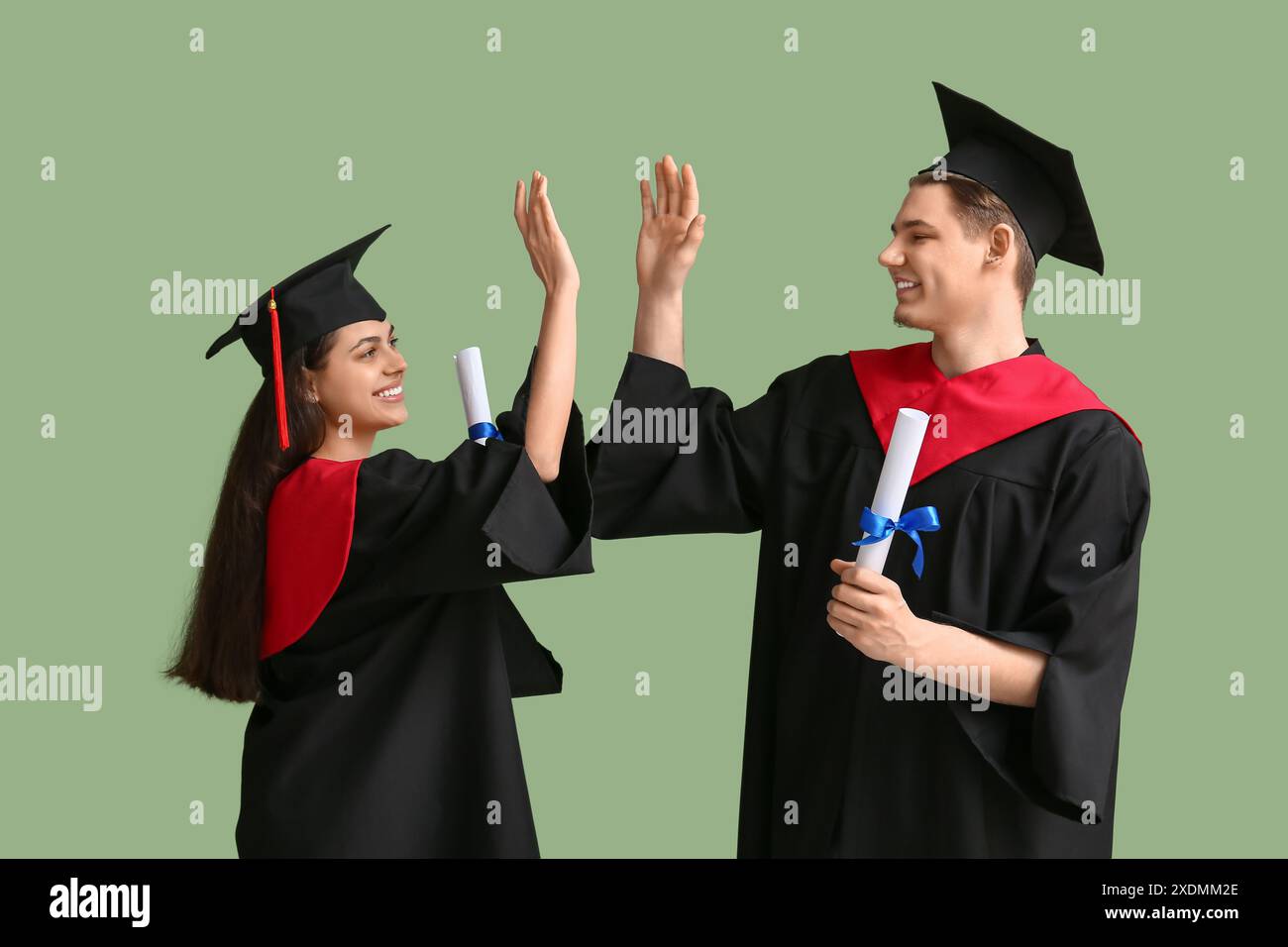 Happy graduate couple with diplomas giving high-five each other on ...
