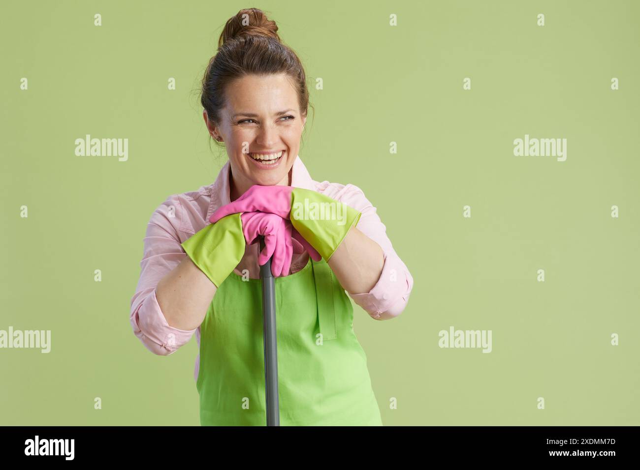 Spring cleaning. happy modern 40 years old woman in green apron and ...
