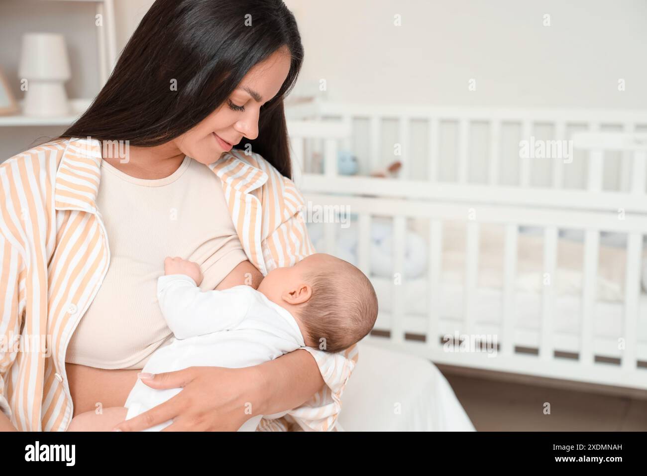 Mother breastfeeding her baby in bedroom Stock Photo - Alamy