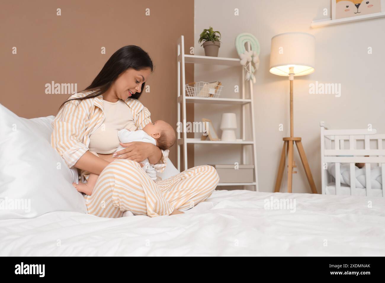 Mother breastfeeding her baby in bedroom Stock Photo - Alamy