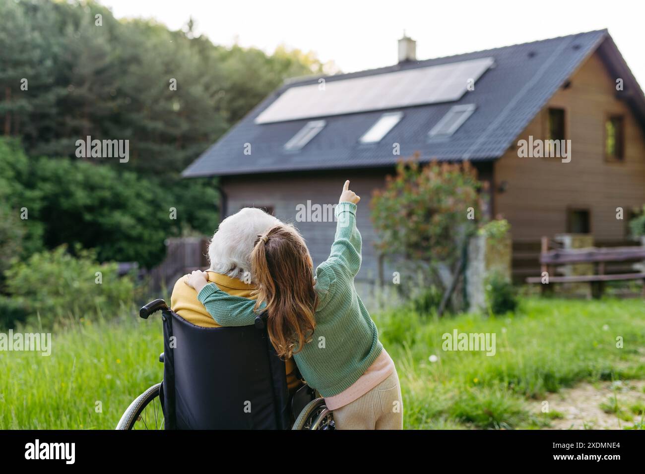 Granddaughter showing grandma solar panels on roof. Senior lady in ...