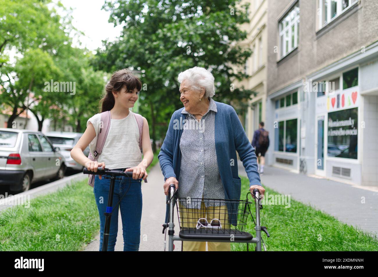 Grandma with walker picking up young girl from school at afternoon ...