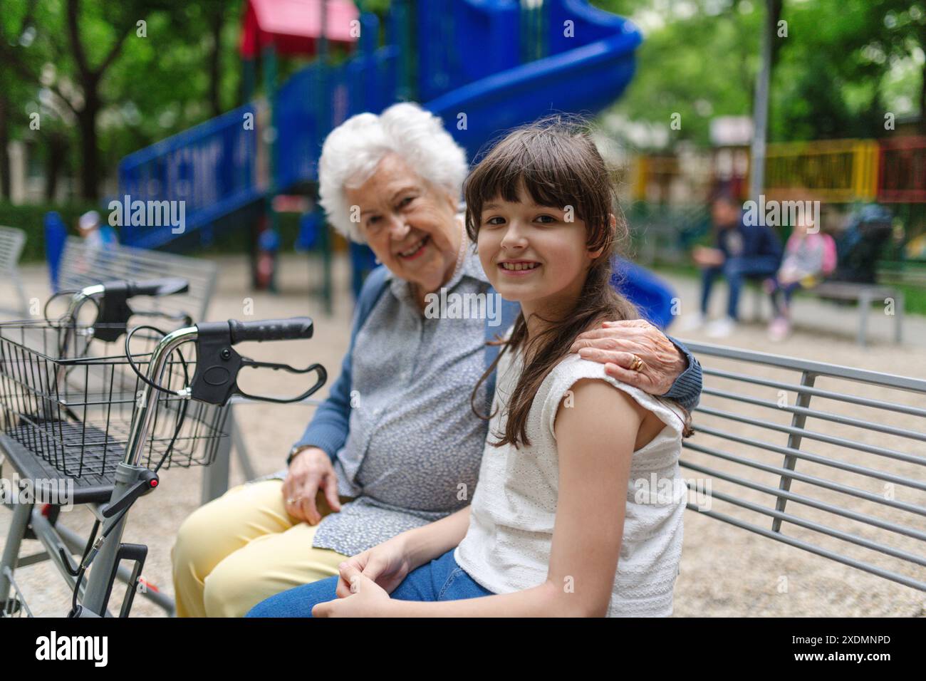 Grandma with walker picking up young girl from school at afternoon ...