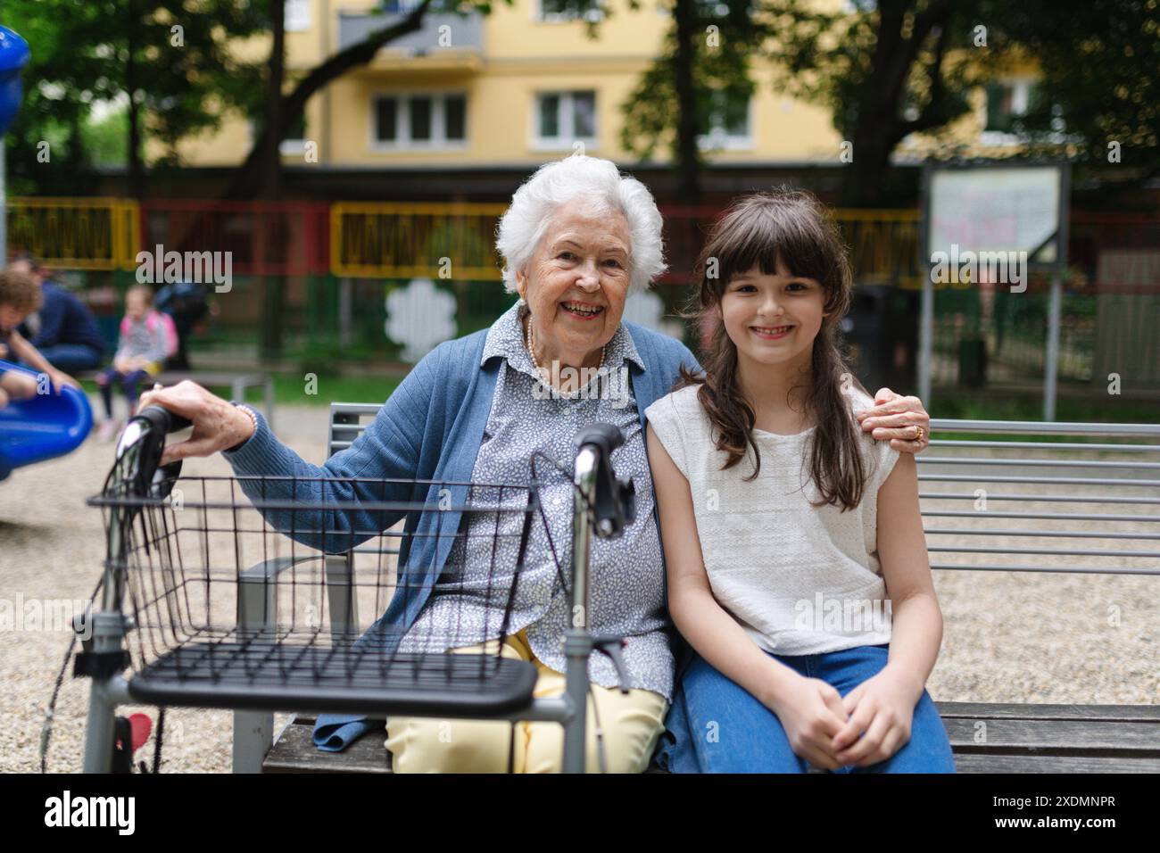Grandma with walker picking up young girl from school at afternoon ...