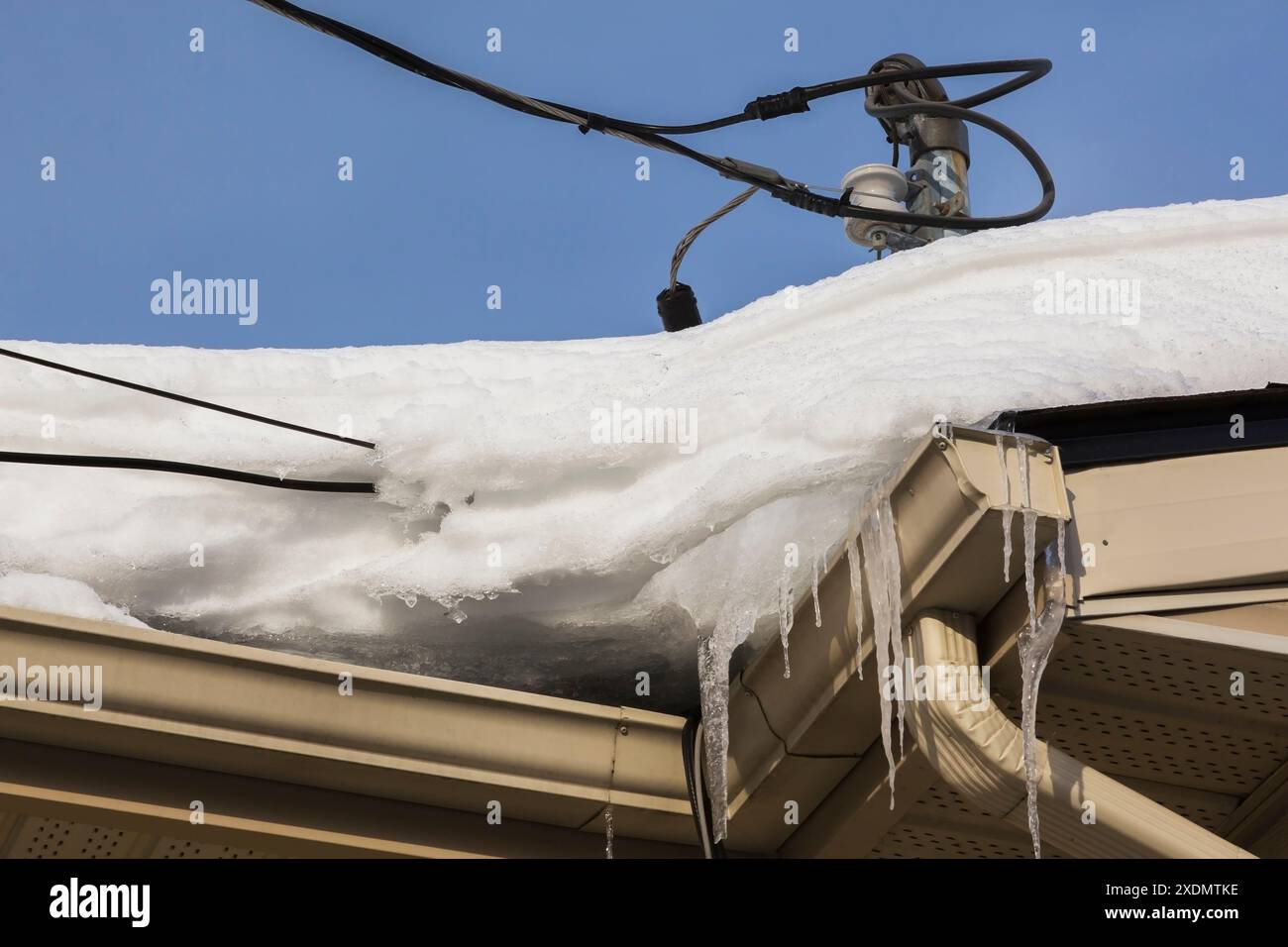 Residential power line service mast on rooftop with cables encased in ...