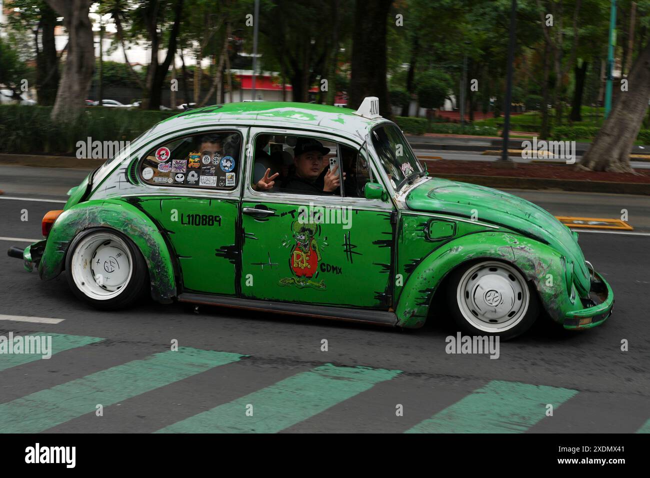 An antique Volkswagen Beetle, known in Mexico as a "vocho," parades ...